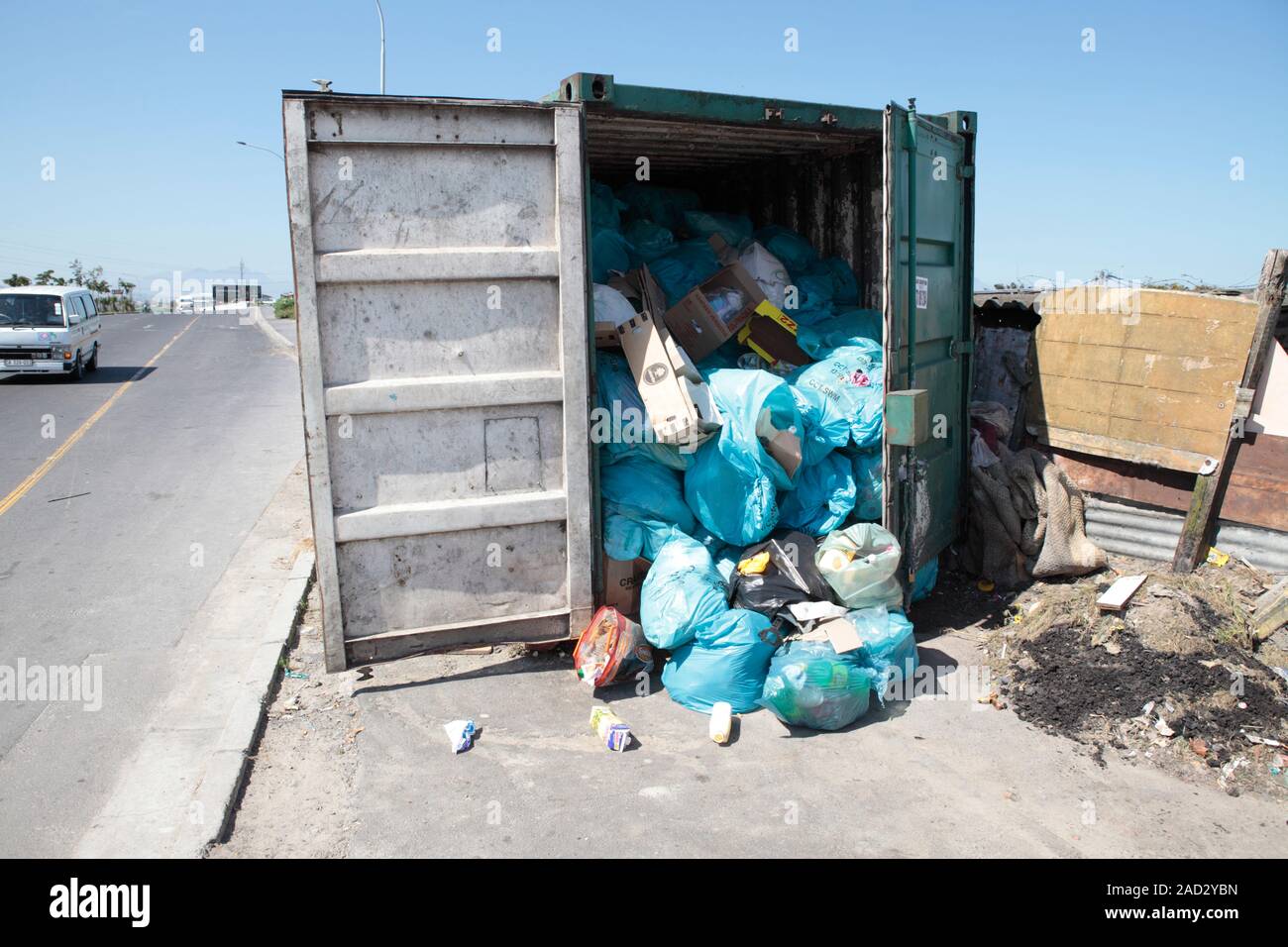 Bags of domestic waste spilling out of a refuse container. Photographed ...