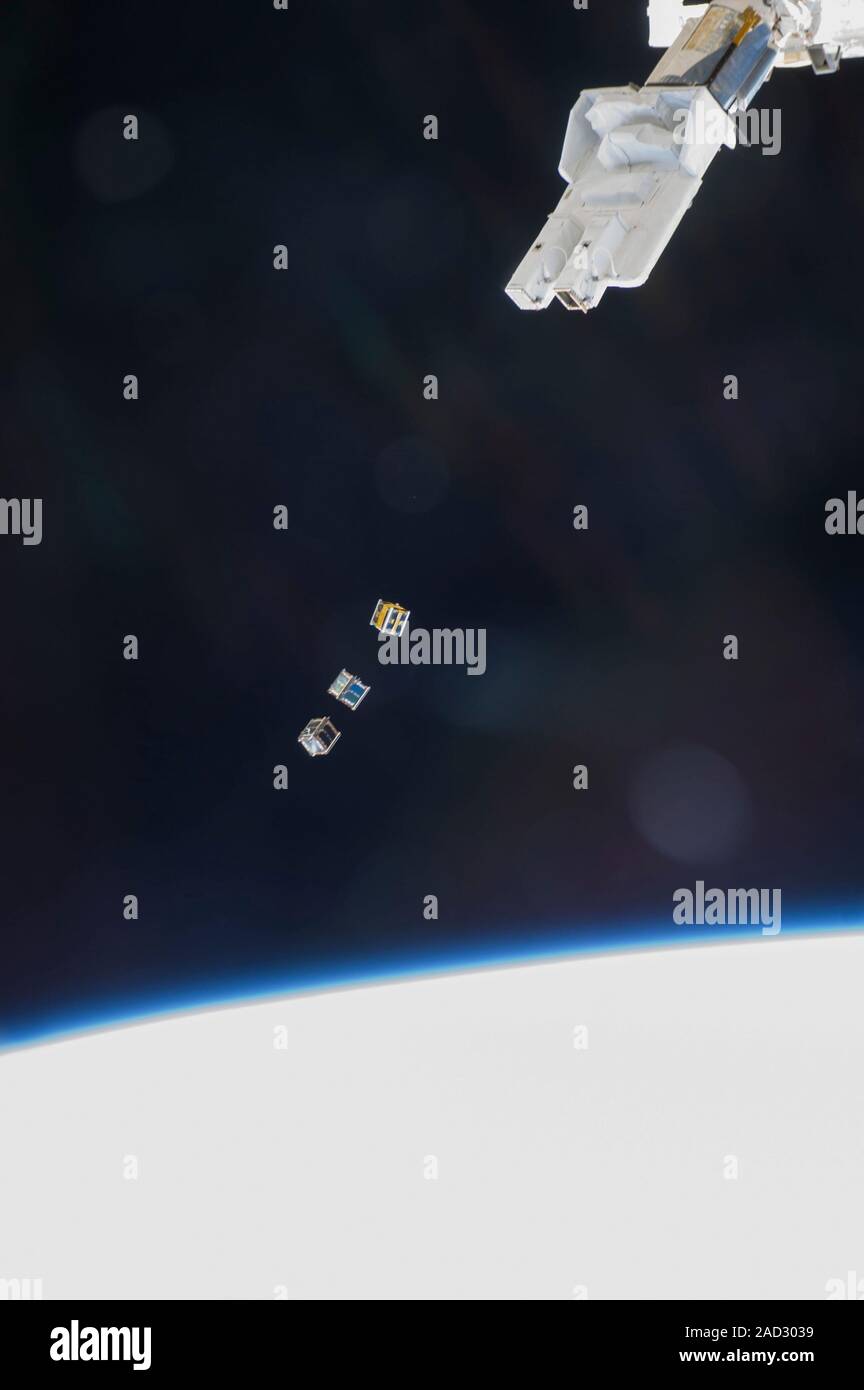 ISS deploying satellites. Astronaut photograph of three nanosatellites ...