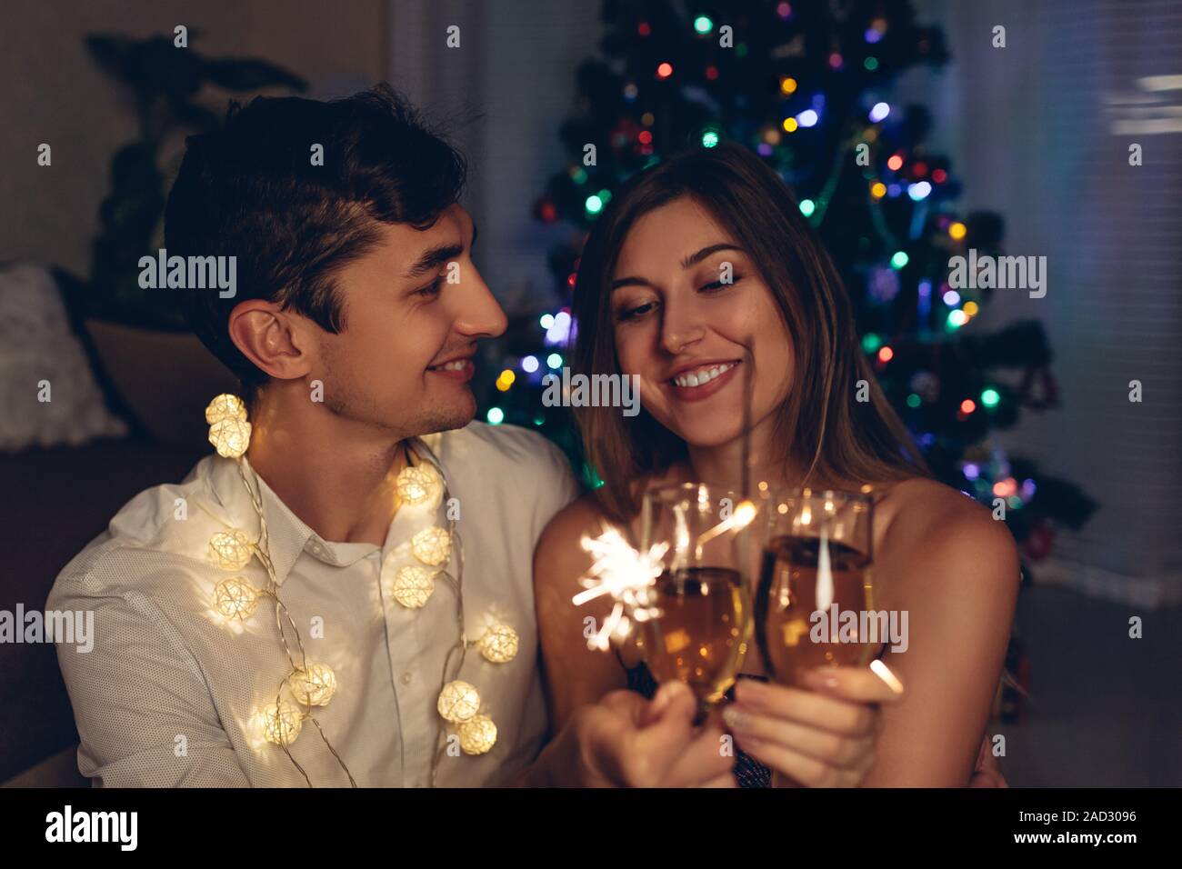 Christmas and New year party concept. Couple in love burning sparklers ...
