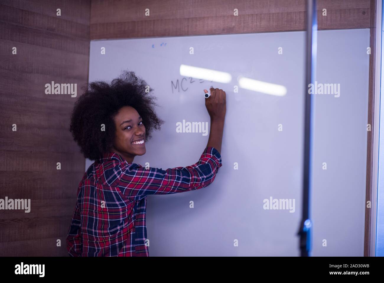black woman writing on a white board in a modern office Stock Photo - Alamy