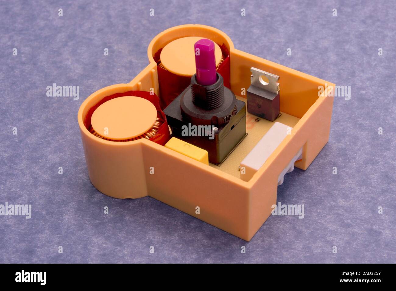 Interior of a domestic light dimmer switch. The black component with ...