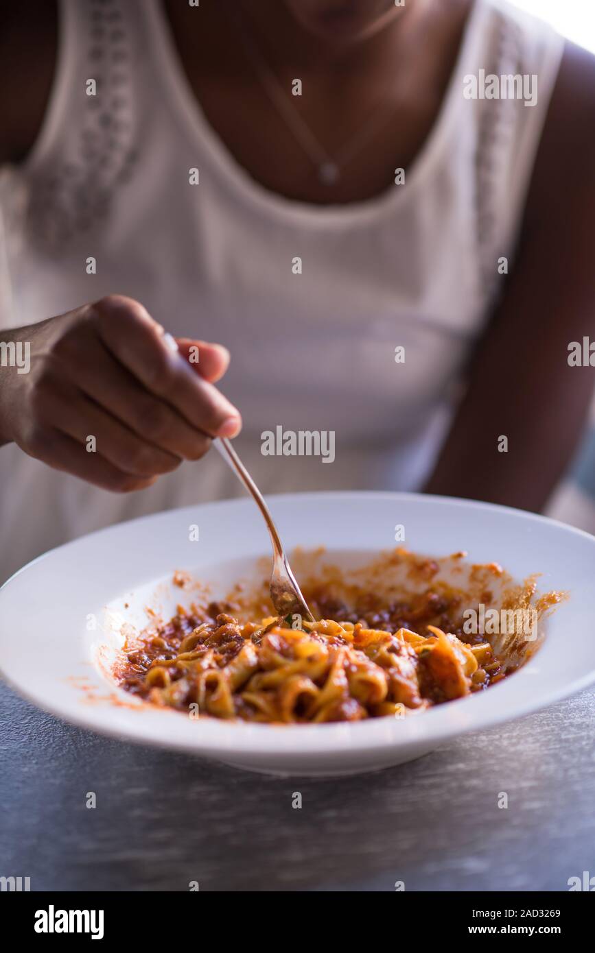 a young African American woman eating pasta Stock Photo - Alamy
