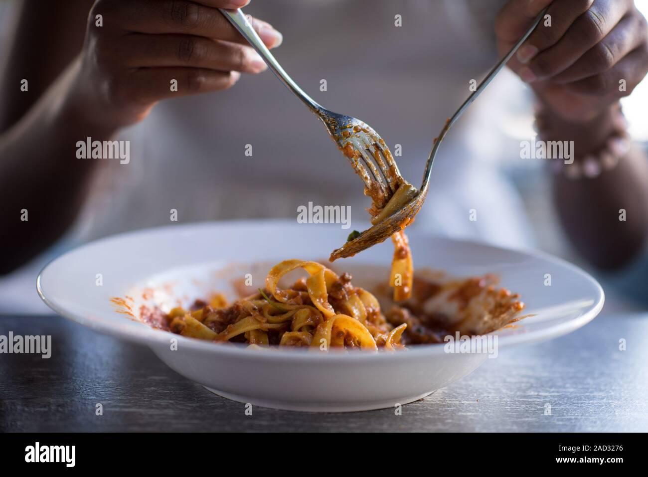 a young African American woman eating pasta Stock Photo - Alamy