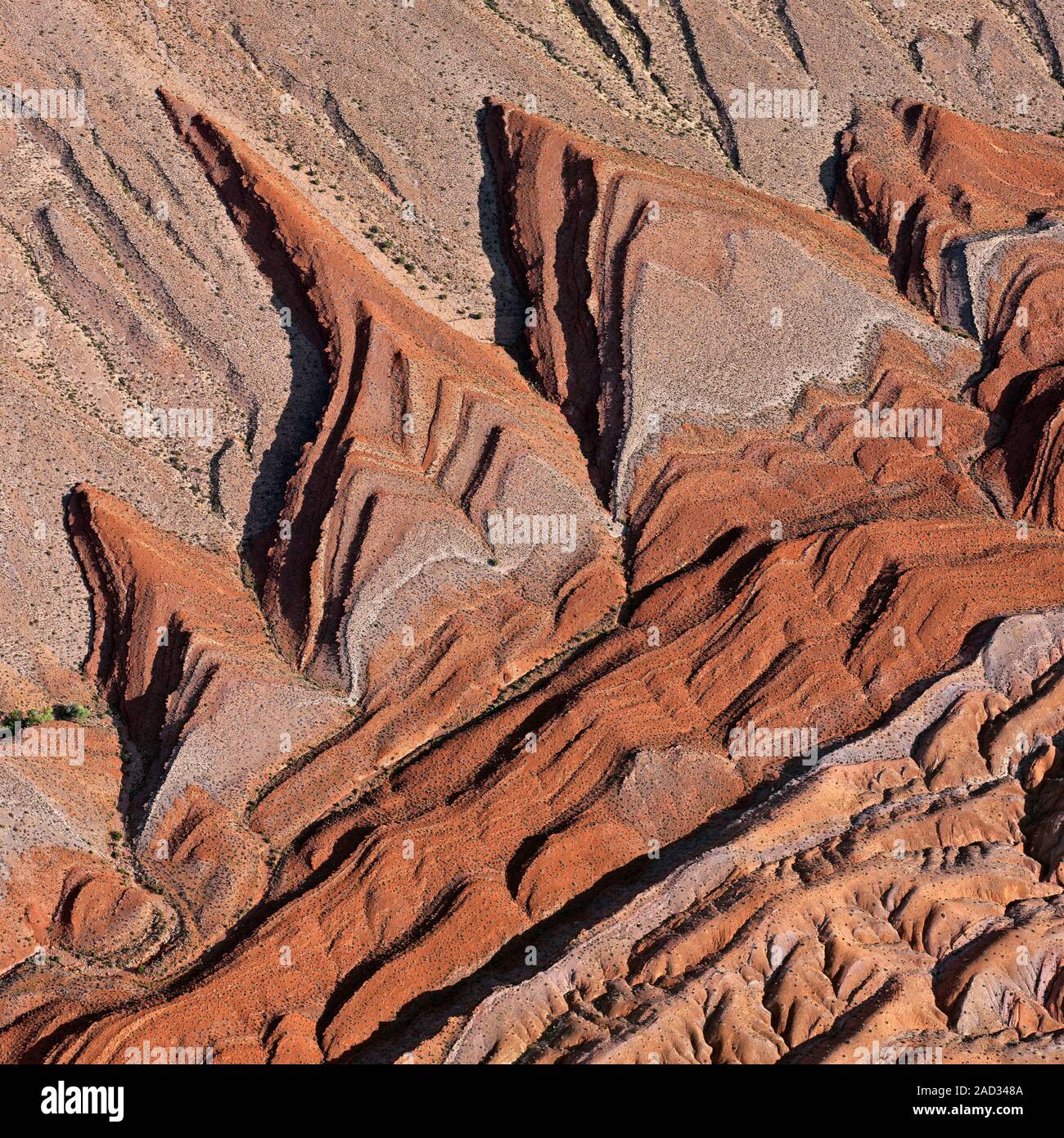 Sandstone layers that have been tilted and then eroded by runoff water ...