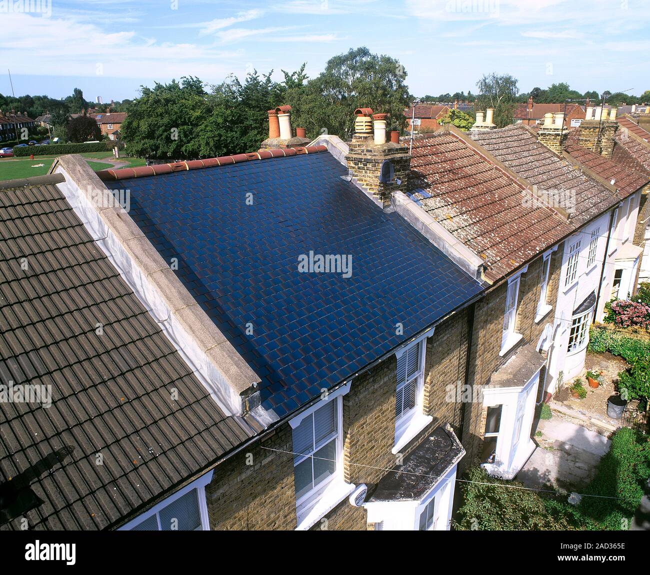 Solar tiles. View of the roof of a house tiled using tiles made out of ...