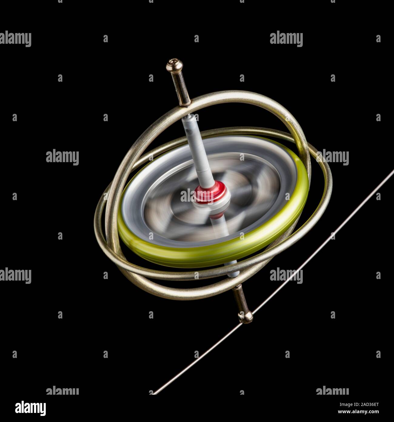 A toy gyroscope balancing on a wire. A gyroscope is a heavy spinning ...