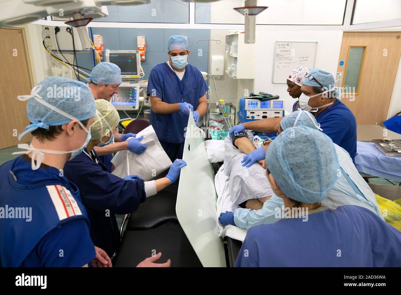 Patient transfer following surgery. Members of a surgical team ...