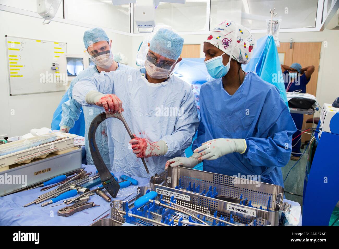 Bone surgery tool. Surgeon adjusting a tool being used during bone ...