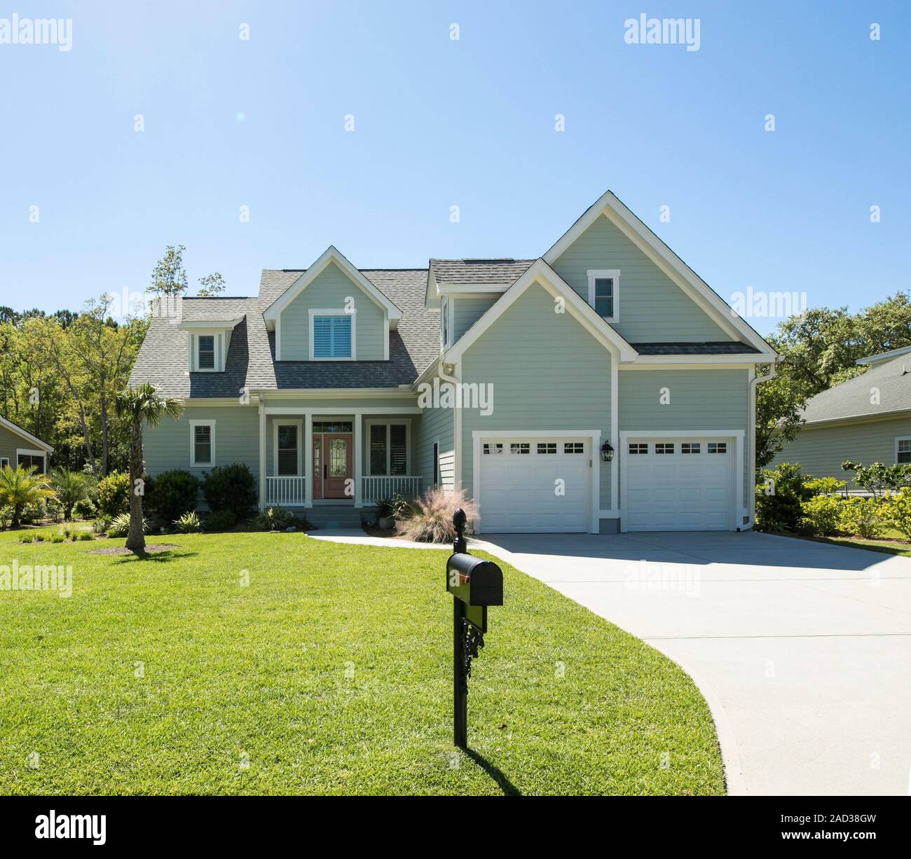 Large beautiful new home on landscaped lot with lawn Stock Photo - Alamy