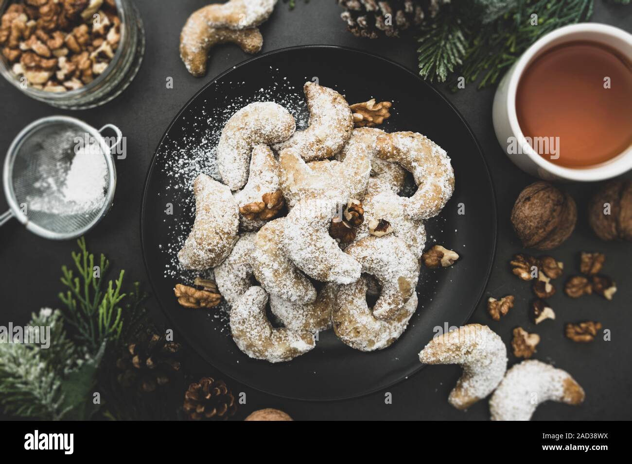 Homemade Christmas cookies with nuts, cup of tea and winter decorations ...
