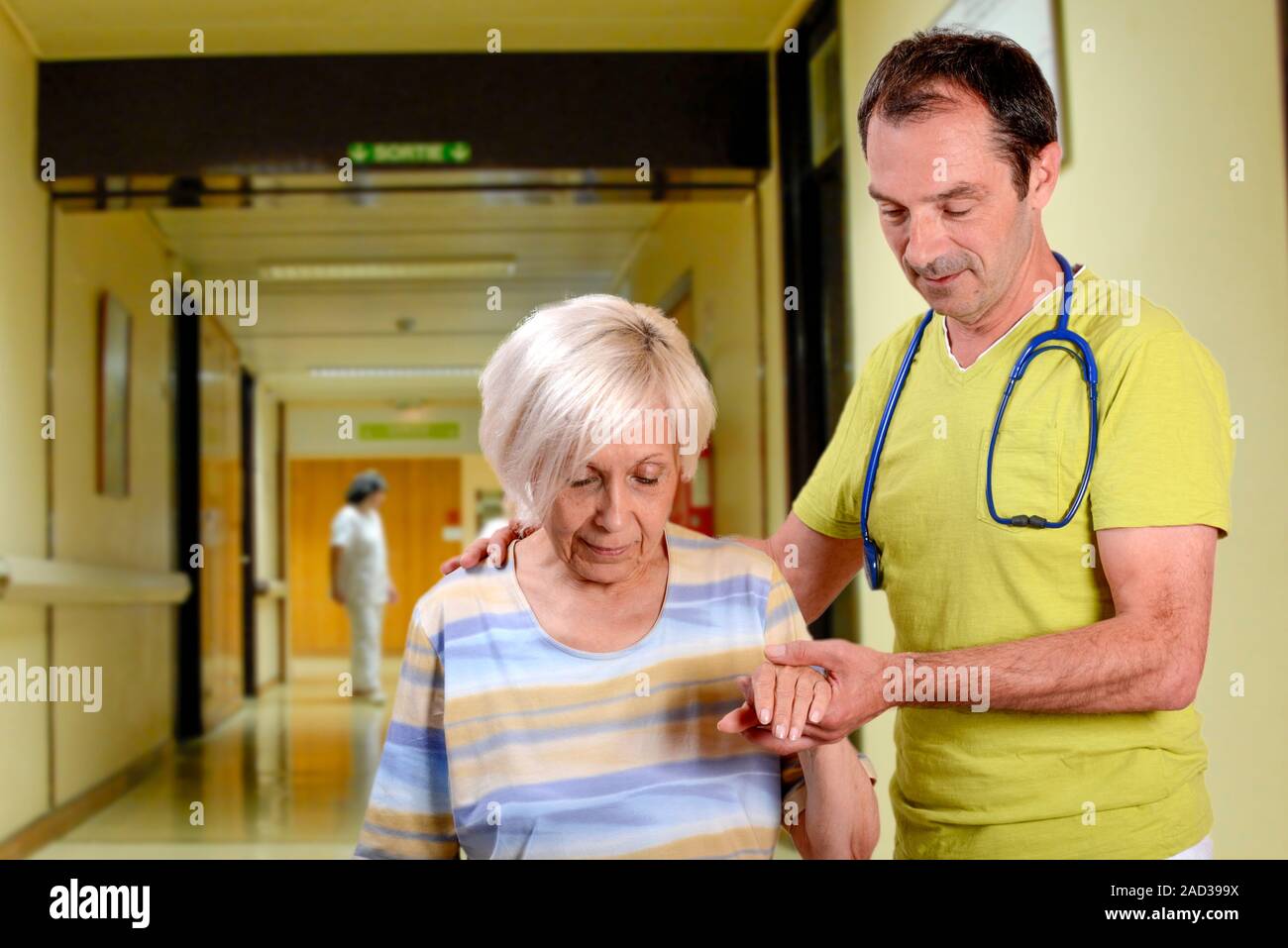 Hospital doctor assisting elderly woman. Doctor helping a 75-year-old ...