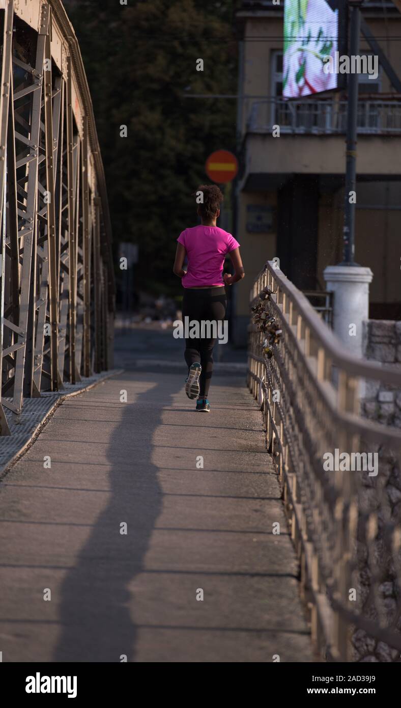 african american woman running across the bridge Stock Photo - Alamy