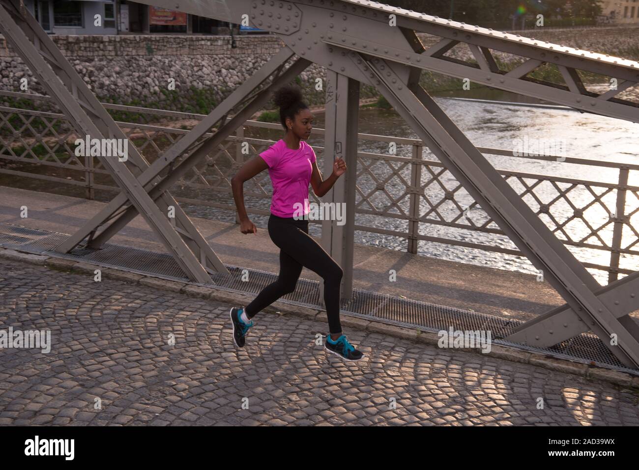 african american woman running across the bridge Stock Photo - Alamy