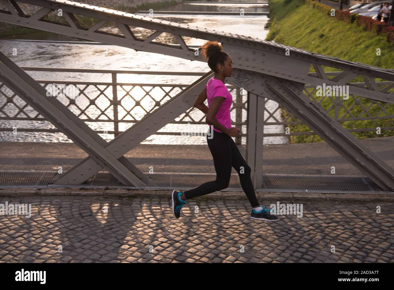 african american woman running across the bridge Stock Photo - Alamy