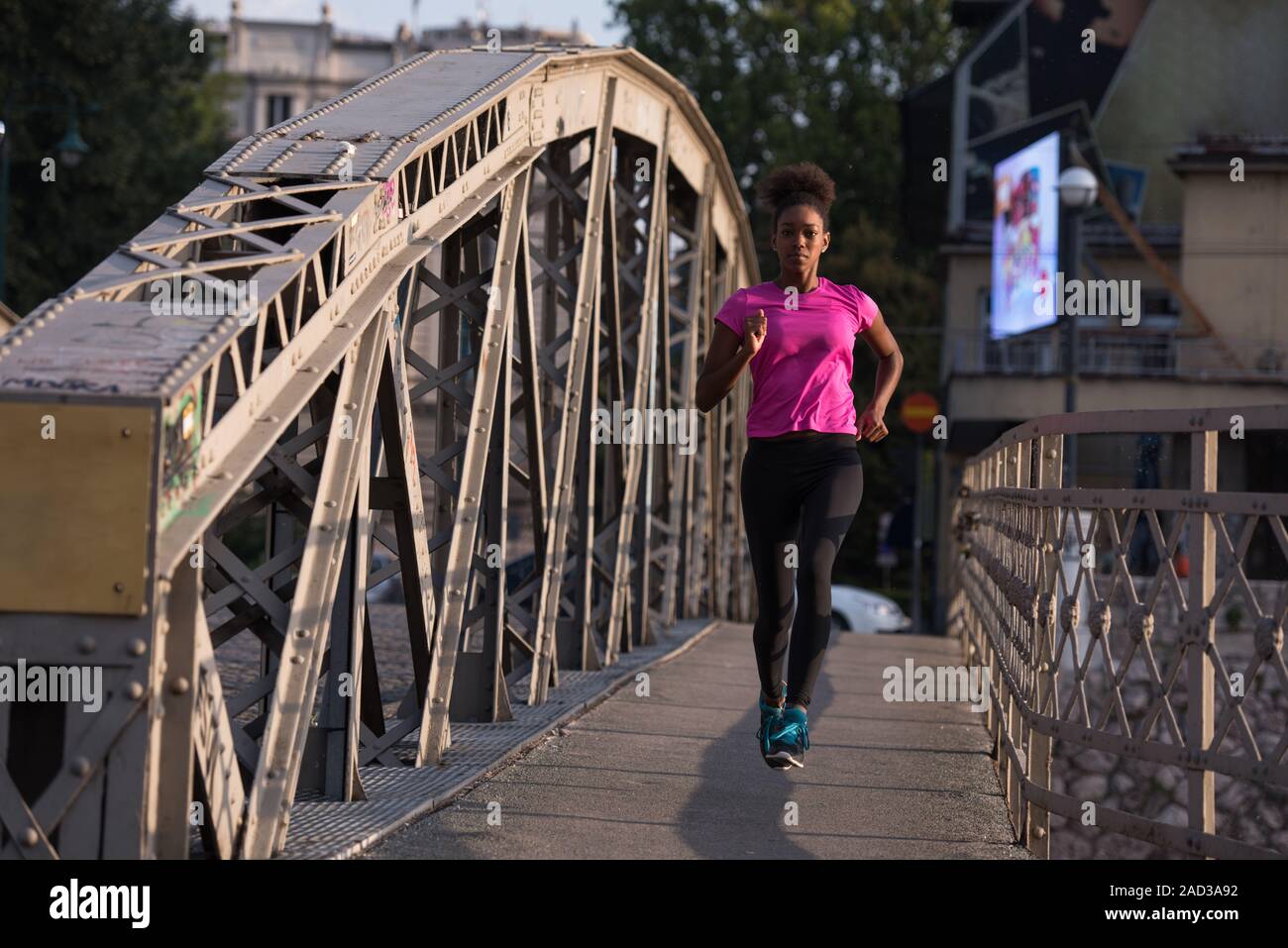 african american woman running across the bridge Stock Photo - Alamy