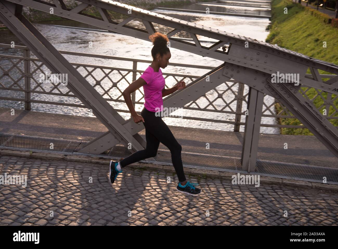 african american woman running across the bridge Stock Photo - Alamy