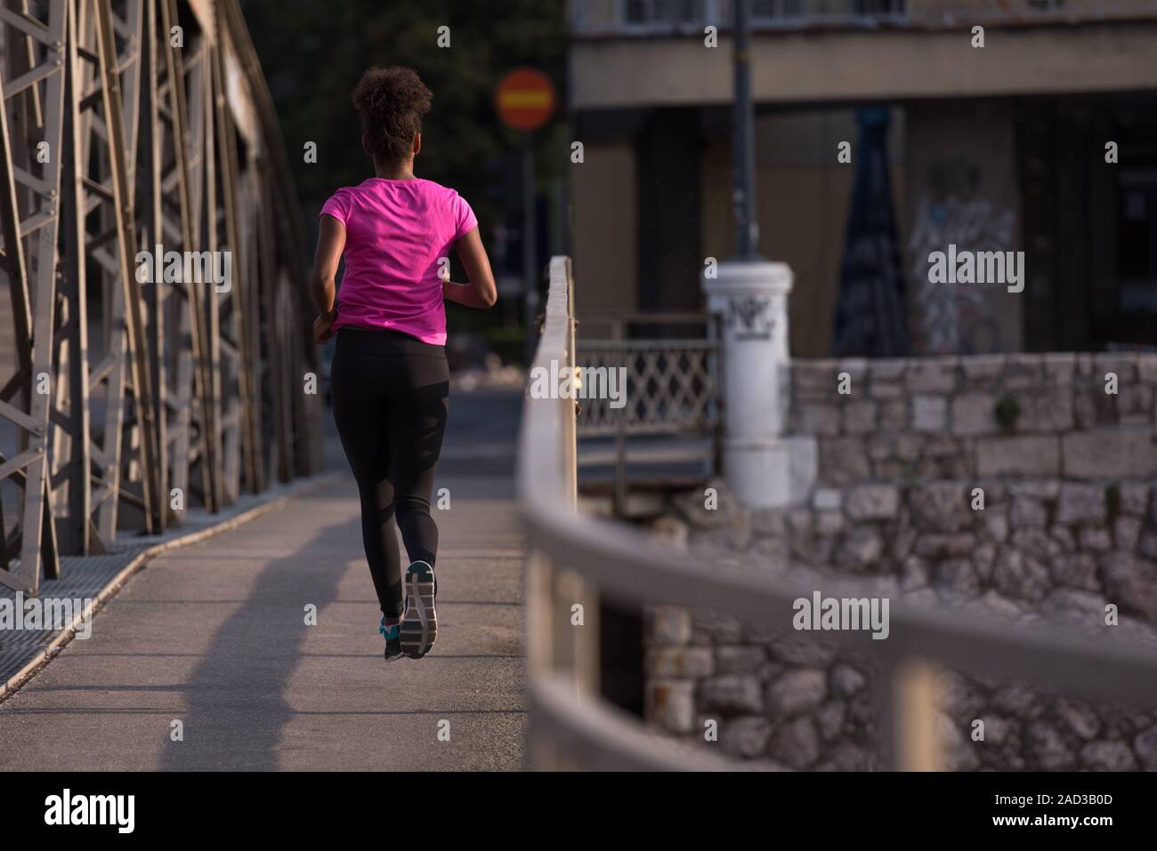 african american woman running across the bridge Stock Photo - Alamy