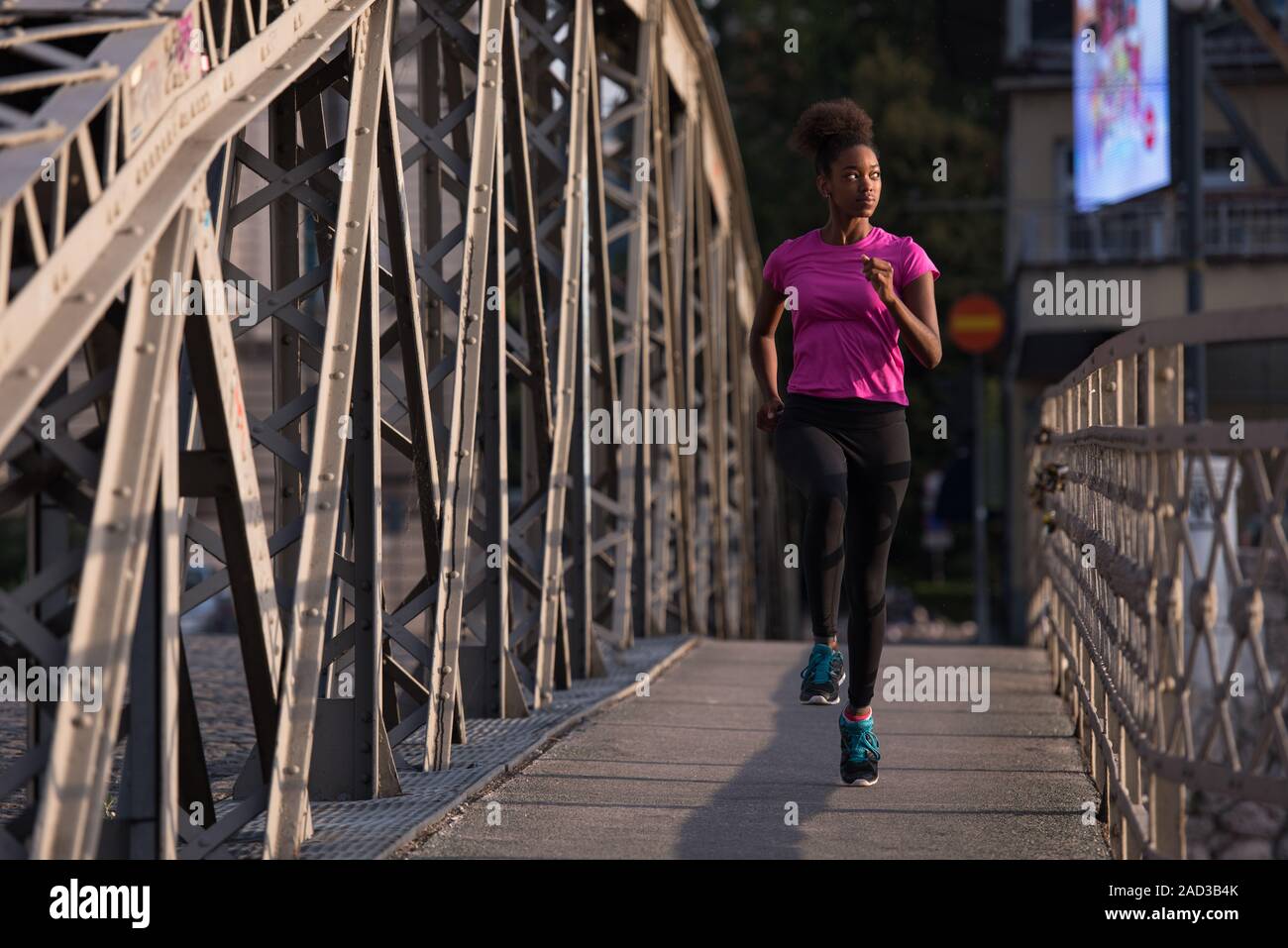 african american woman running across the bridge Stock Photo - Alamy