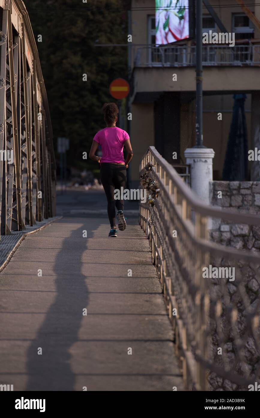 african american woman running across the bridge Stock Photo - Alamy