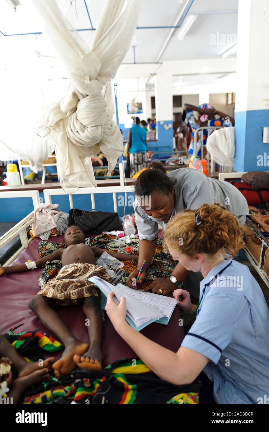 Nursing in Sierra Leone. Nurses assisting each other on a ward at the ...