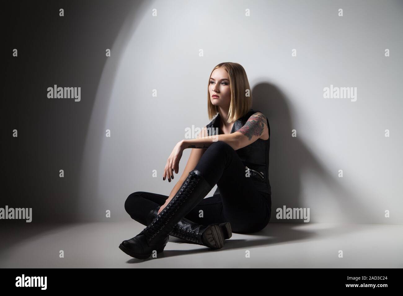 Stylish girl bending on wall Stock Photo - Alamy