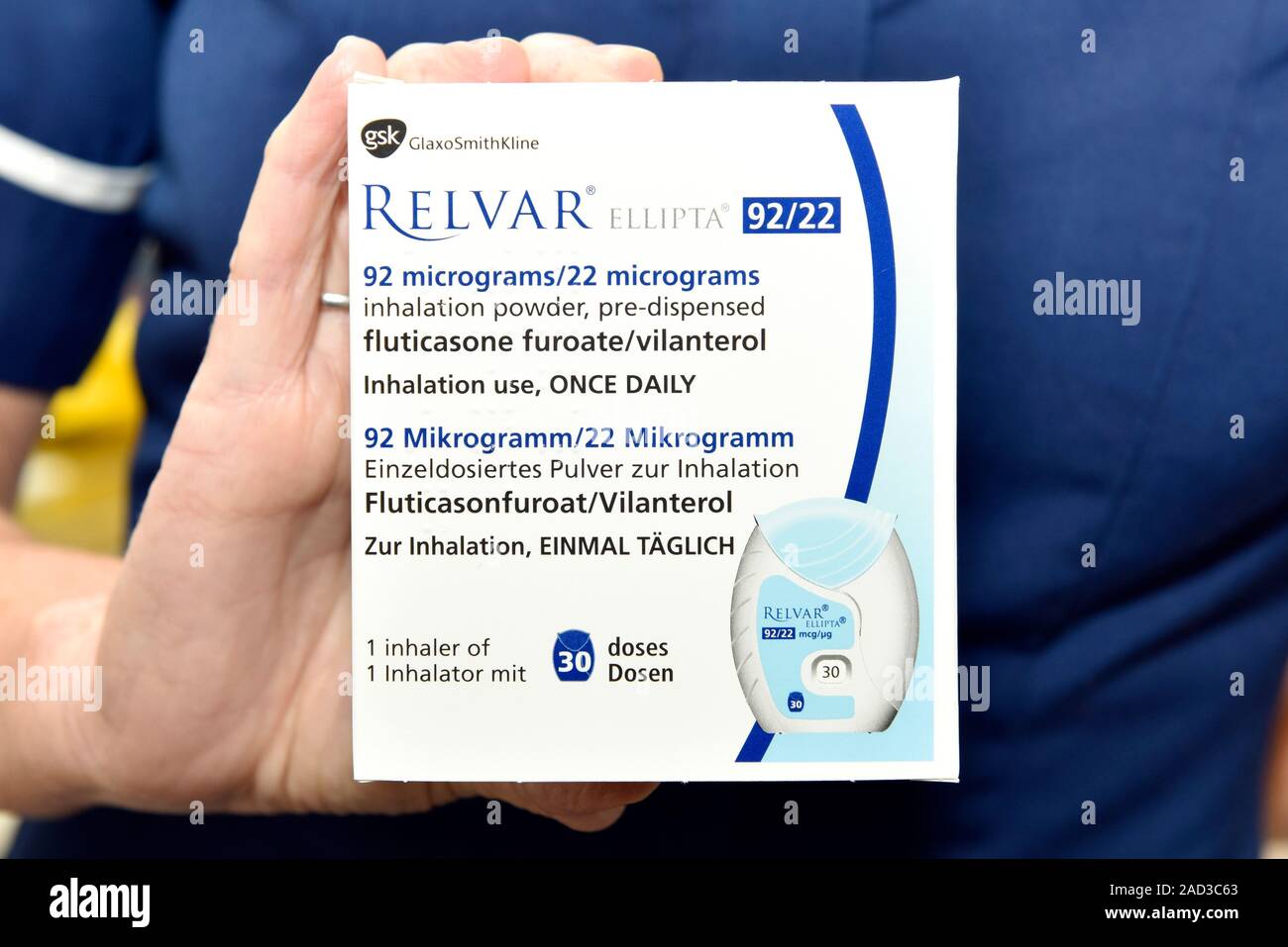 Asthma inhaler. Nurse holding a box containing an inhaler used to ...