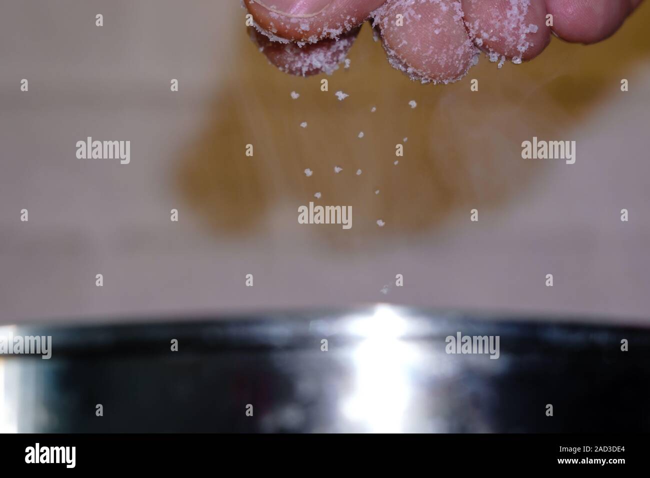 salt food close up cooking in a pot. homemade meal add salt spices ...