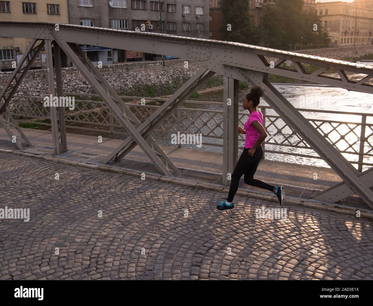 african american woman running across the bridge Stock Photo - Alamy
