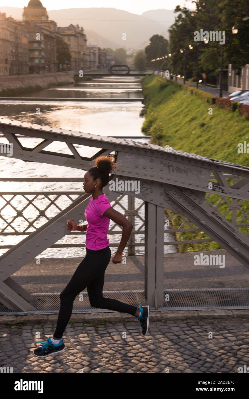 african american woman running across the bridge Stock Photo - Alamy