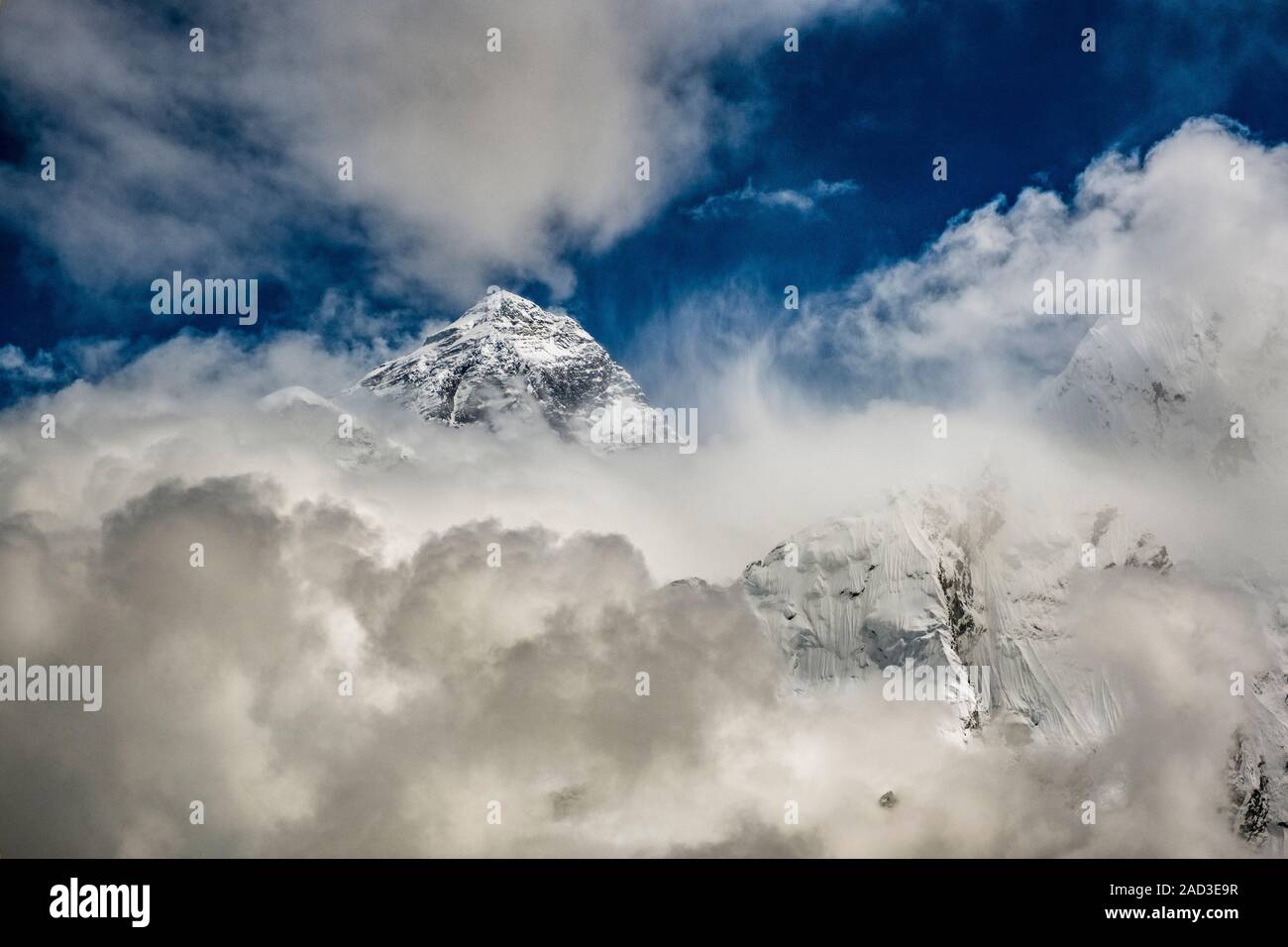 The summit of Mt. Everest surrounded by monsoon clouds rising up, seen ...