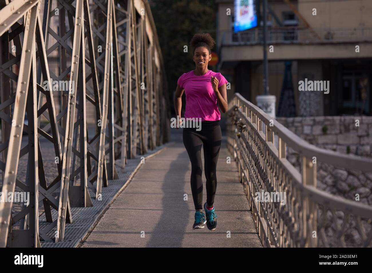 african american woman running across the bridge Stock Photo - Alamy