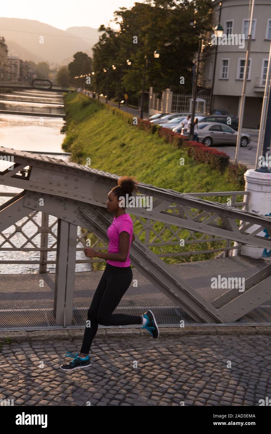 african american woman running across the bridge Stock Photo - Alamy
