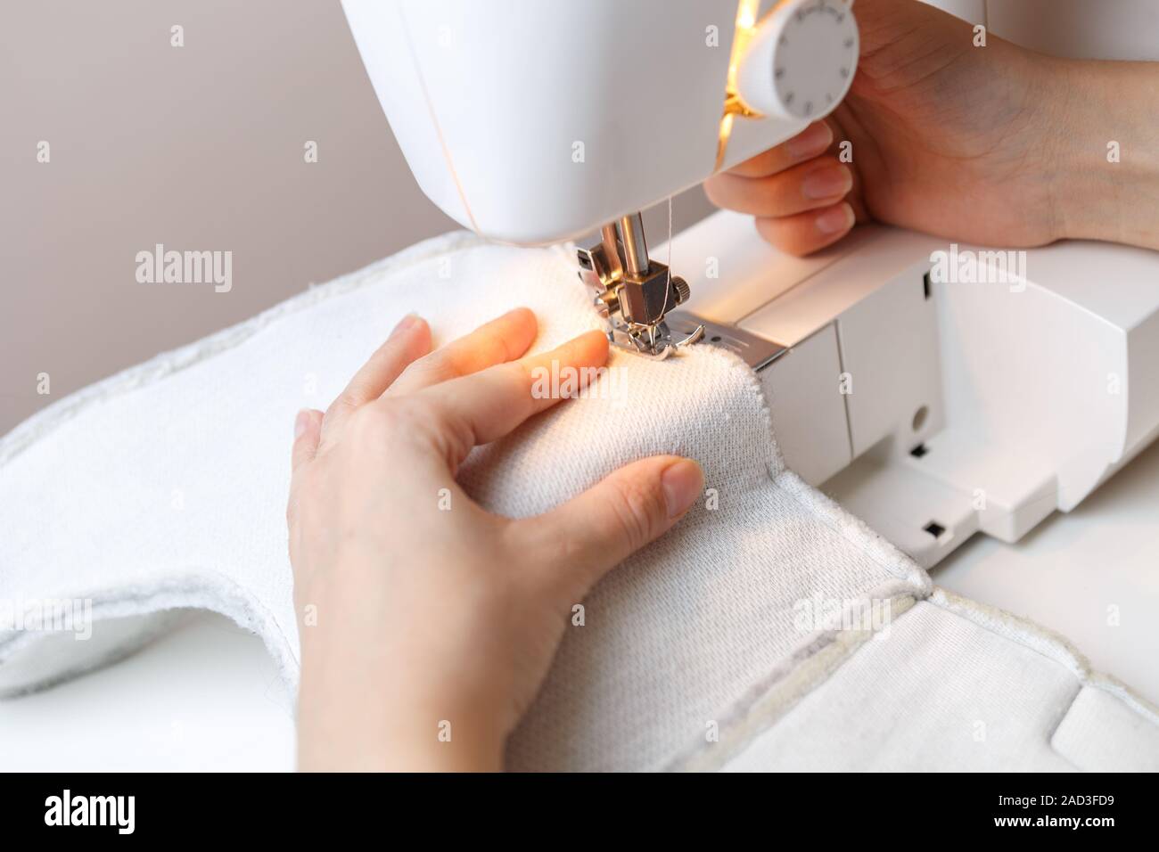 Woman starts tailoring on sewing-machine Stock Photo - Alamy