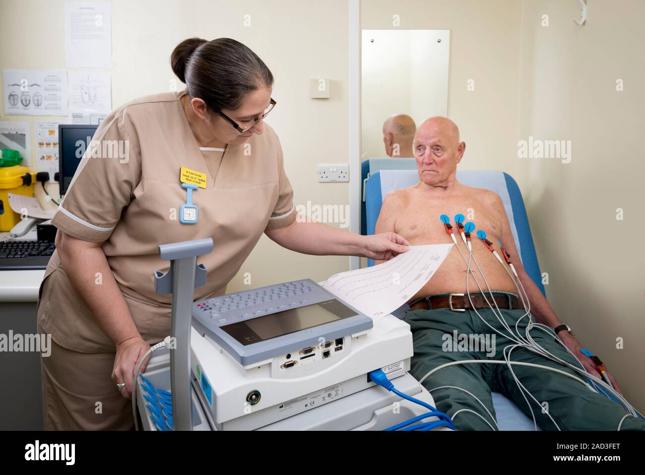 Electrocardiography test. Nurse carrying out an electrocardiography ...