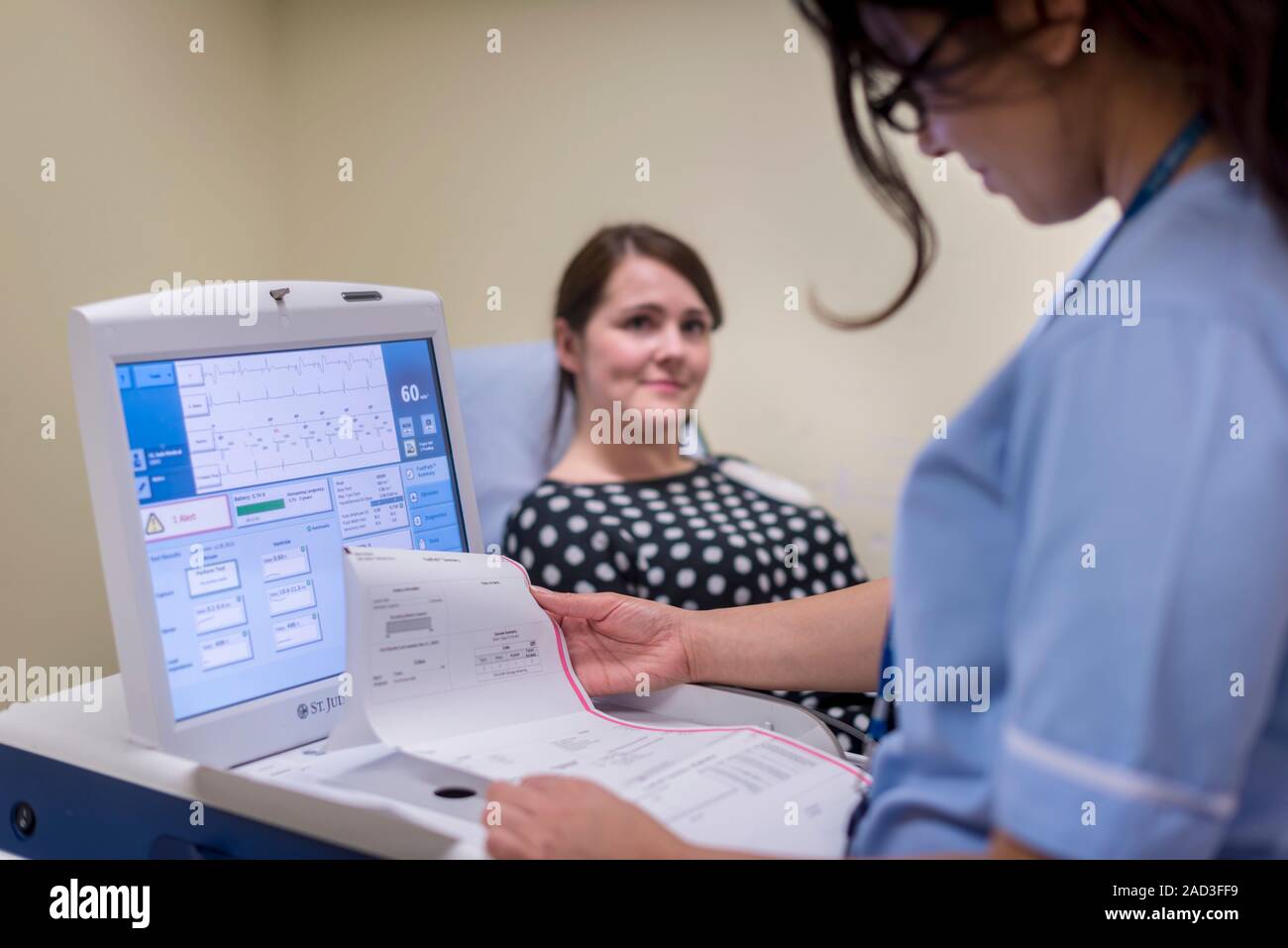 Pacemaker tests. Nurse in a hospital's cardiology department carrying ...