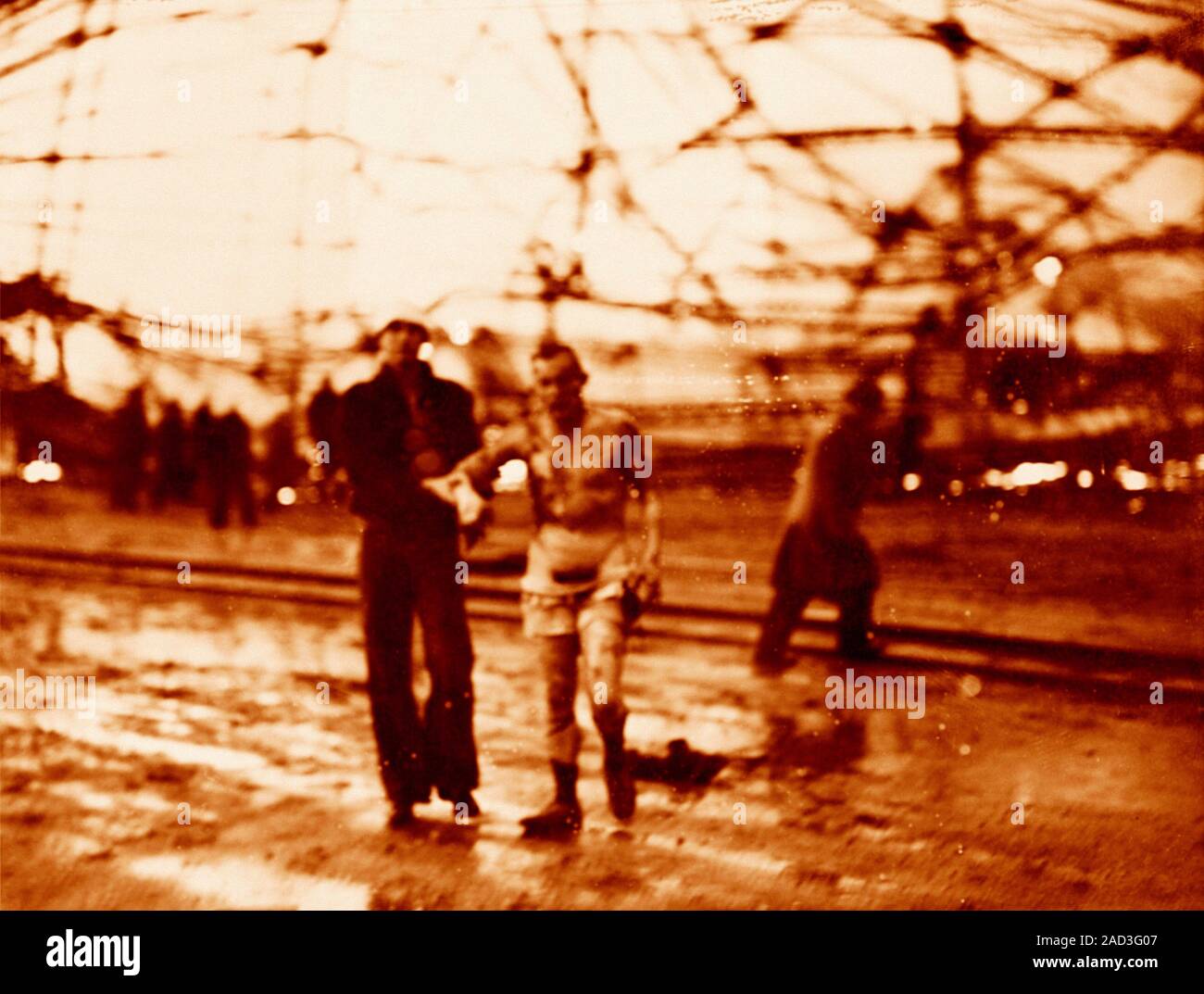 Hindenburg disaster, coloured image. Sailor helping a survivor of the ...
