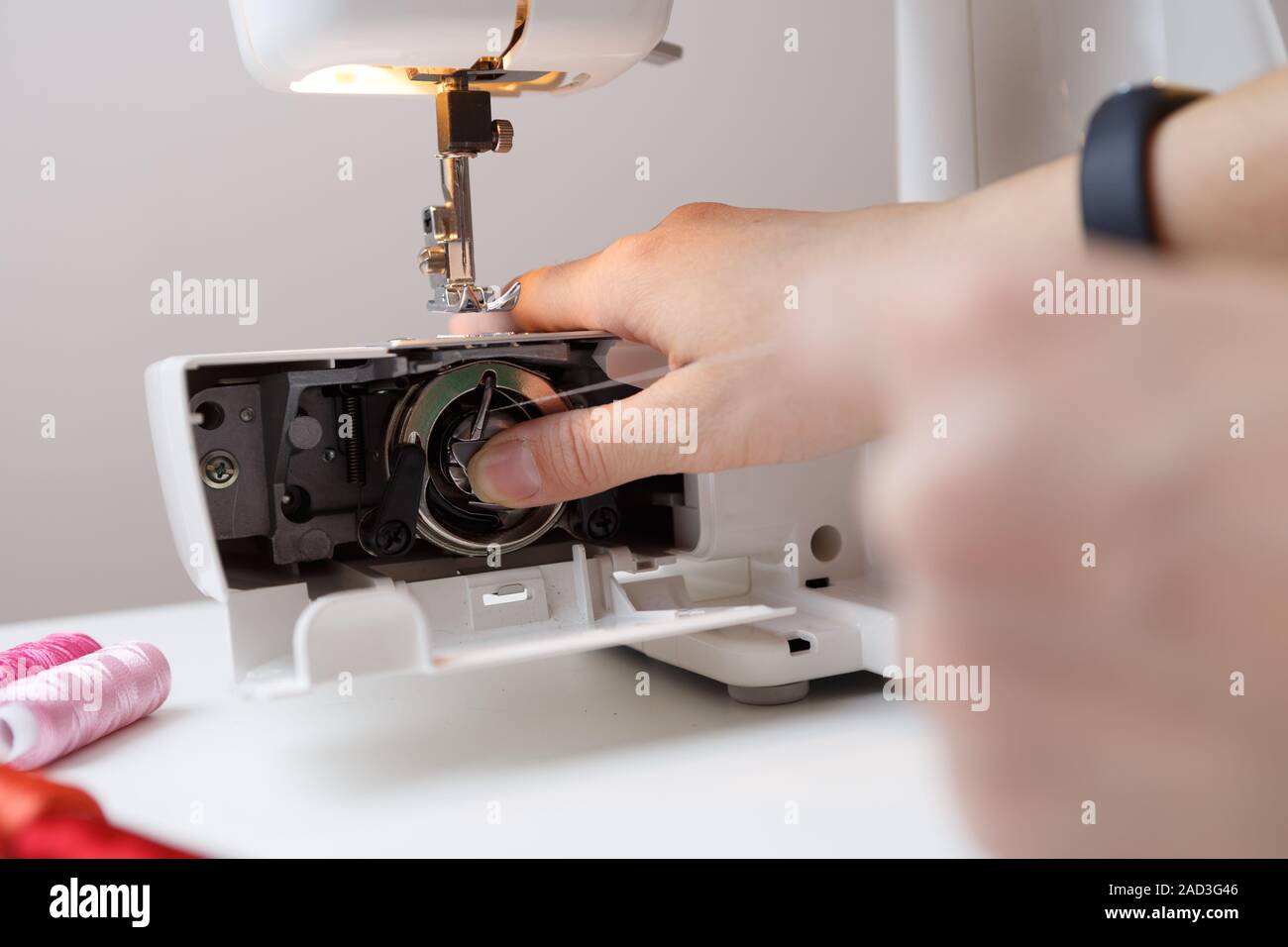 Girl inserts bobbin in sewing-machine Stock Photo - Alamy