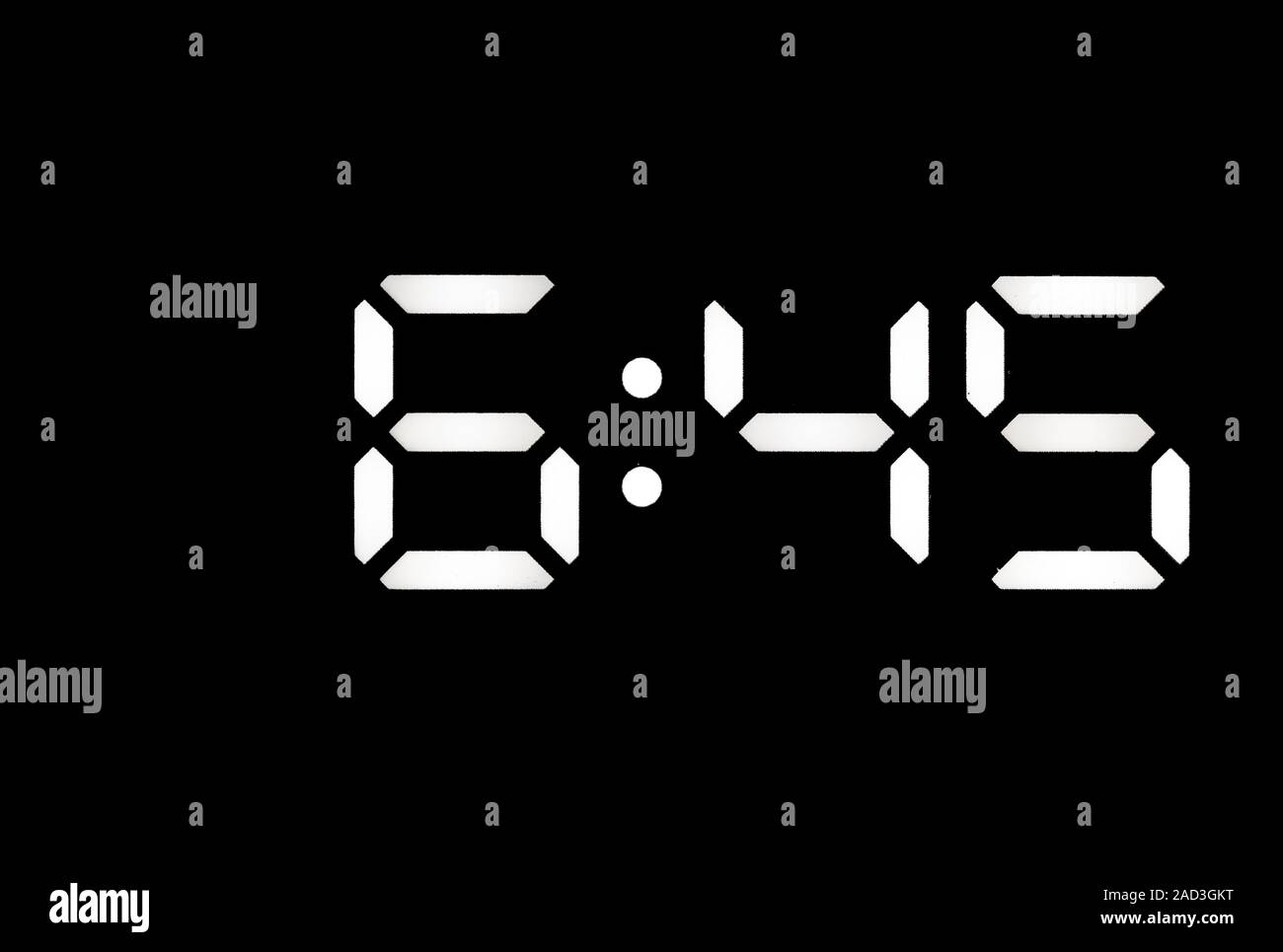 Real white led digital clock on a black background showing time 6:45 ...
