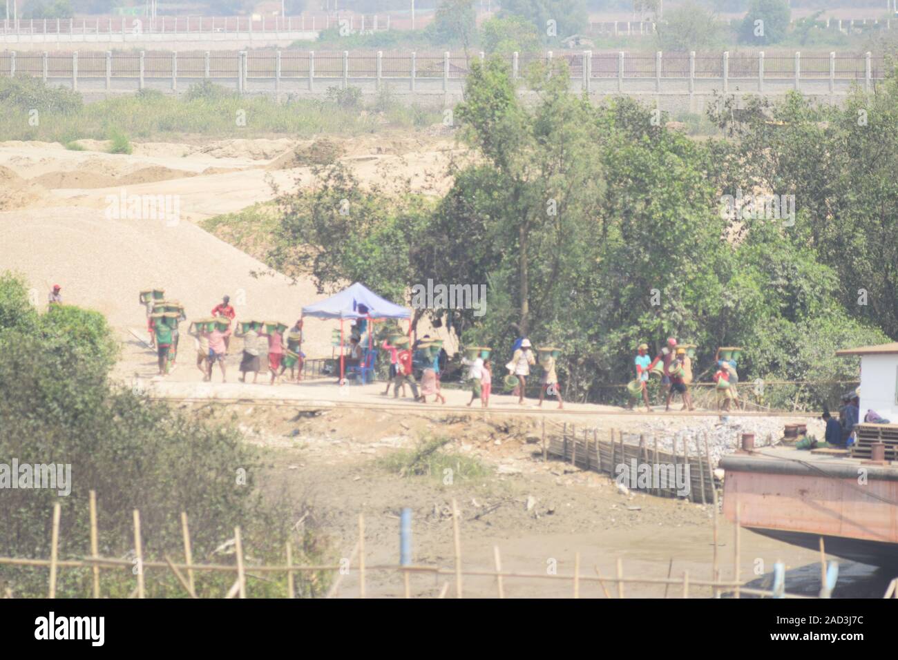 Human mules unloading a barge of gravel aggregate in Yangon, Rangoon ...