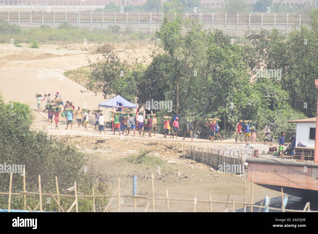 Human mules unloading a barge of gravel aggregate in Yangon, Rangoon ...