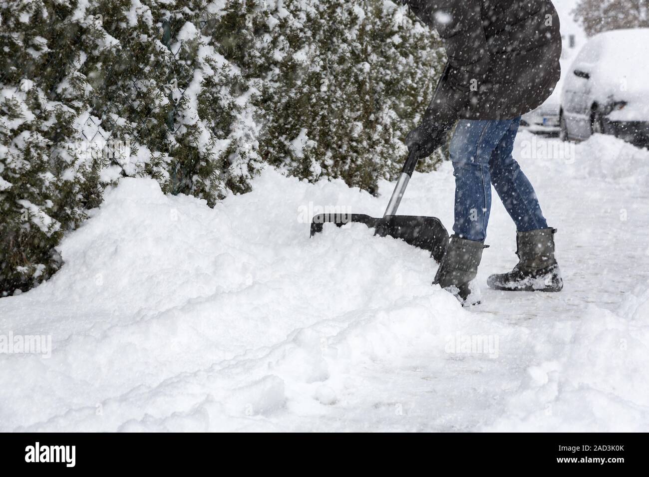 Woman clearing snow on sidewalk Stock Photo - Alamy