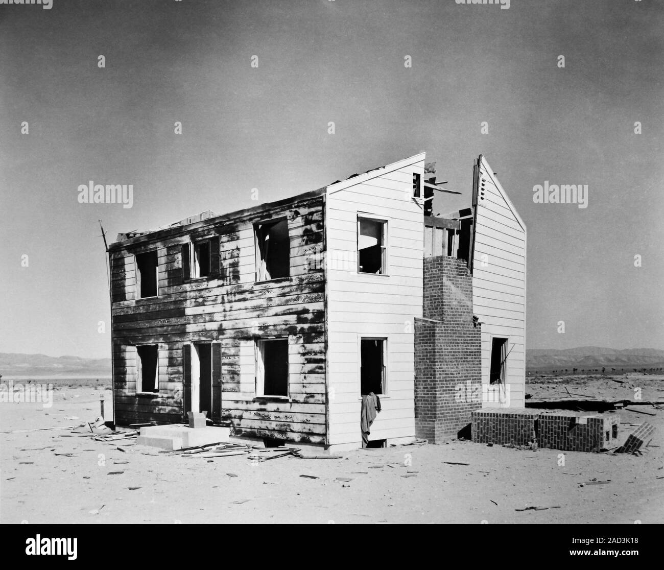 Operation Cue atom bomb test. Image 2 of 2. Two-storey wood-frame house ...