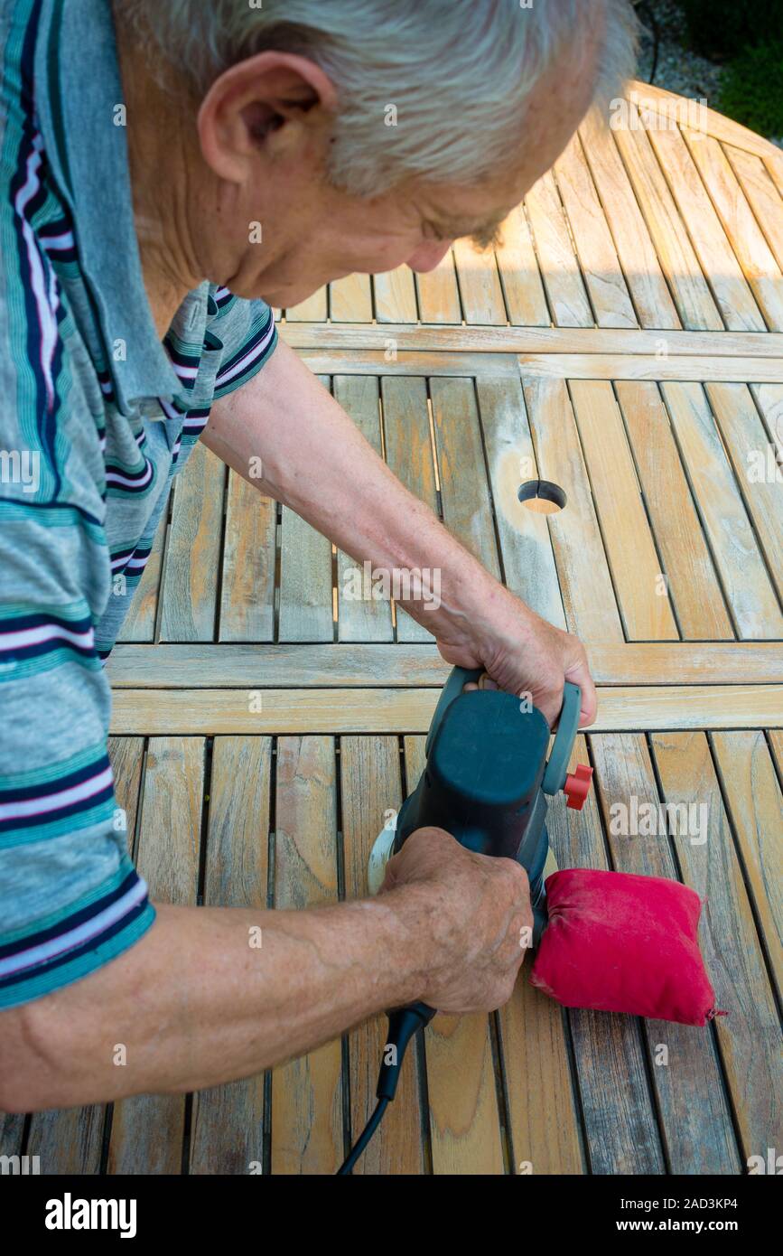 Old man - carpenter working with electric sander Stock Photo - Alamy