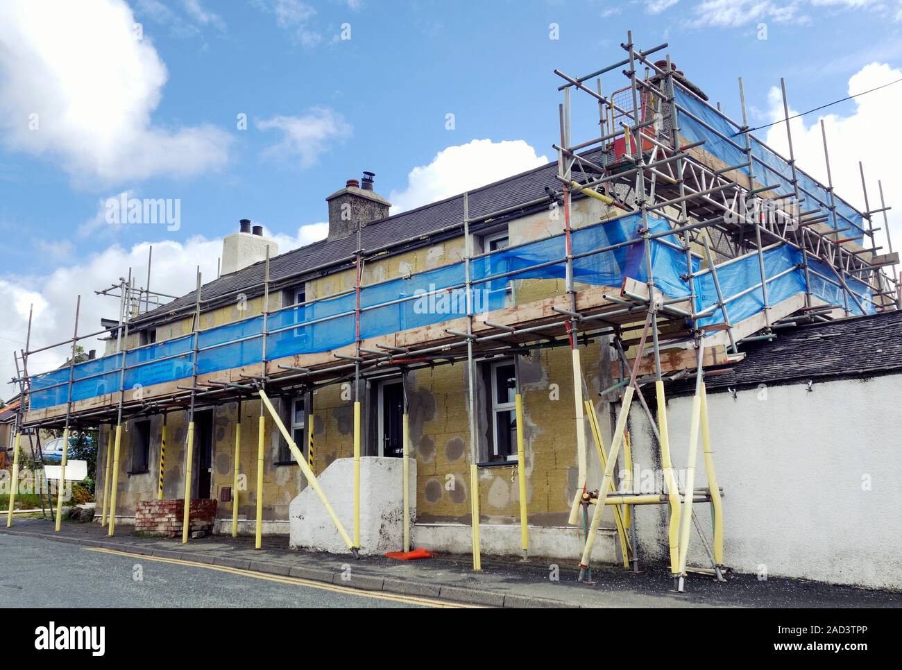 Domestic external wall insulation. An old stone-built house receiving ...