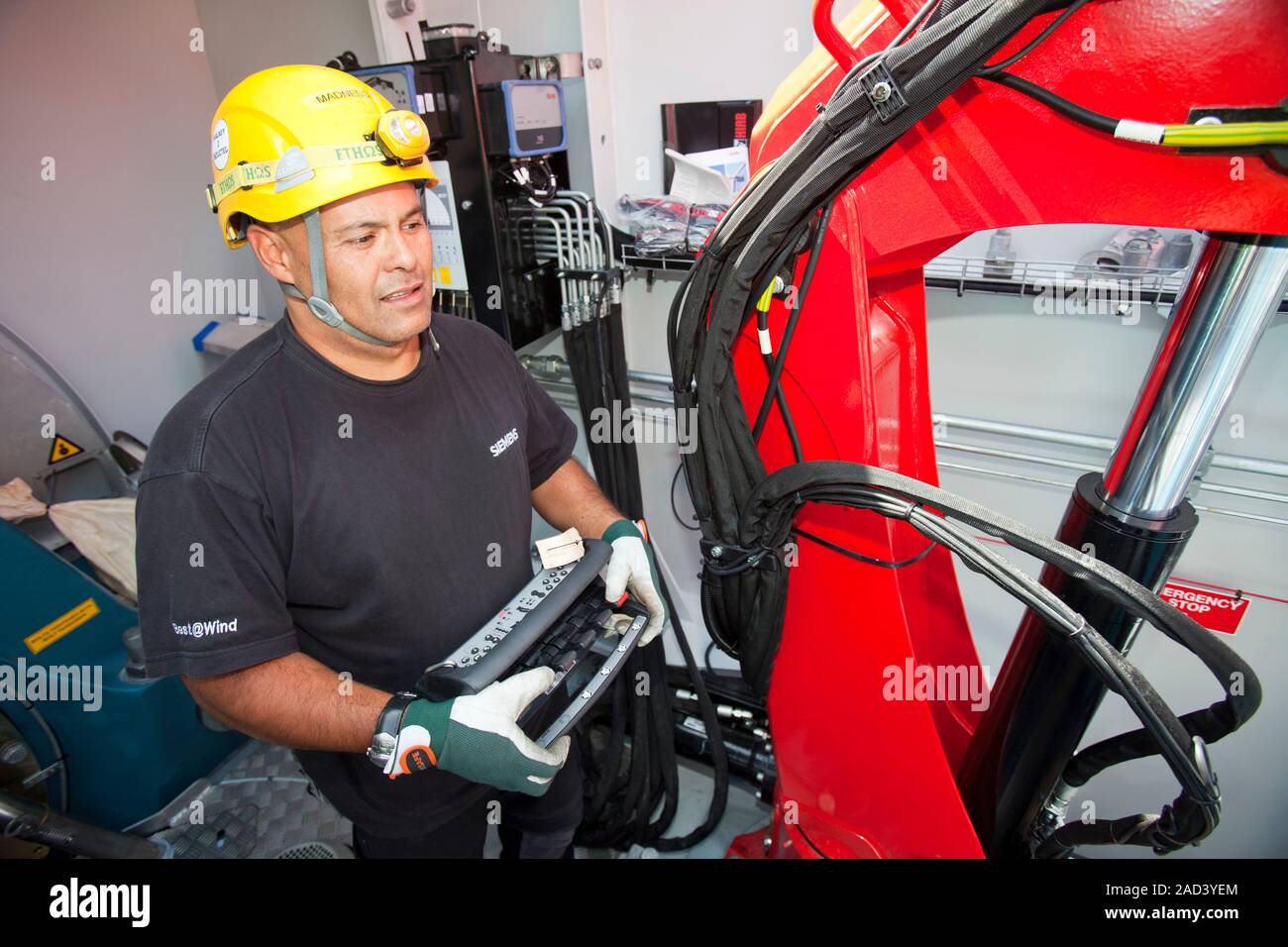 An engineer uses a remote crane lift control to lift parts into place ...