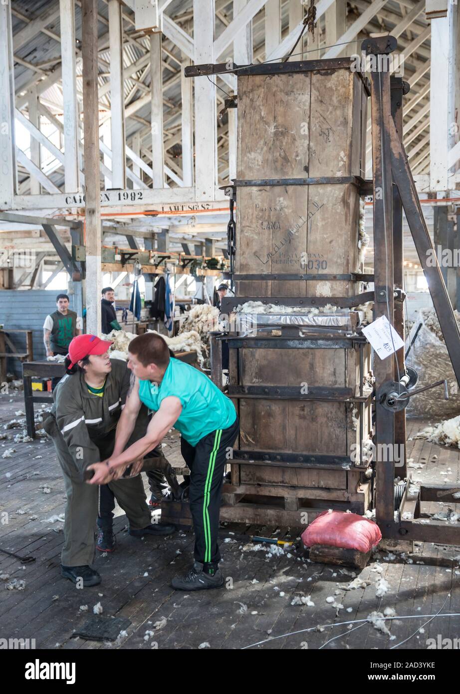 Workers use a traditional wooden wool press to compact between 40-60 ...