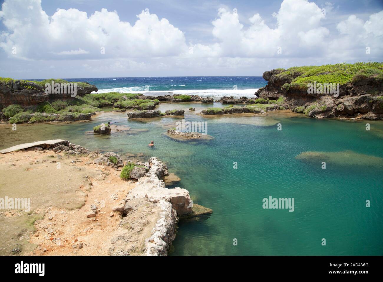 Guam. Man swimming in a shallow saltwater pool near Inarajan, on the ...