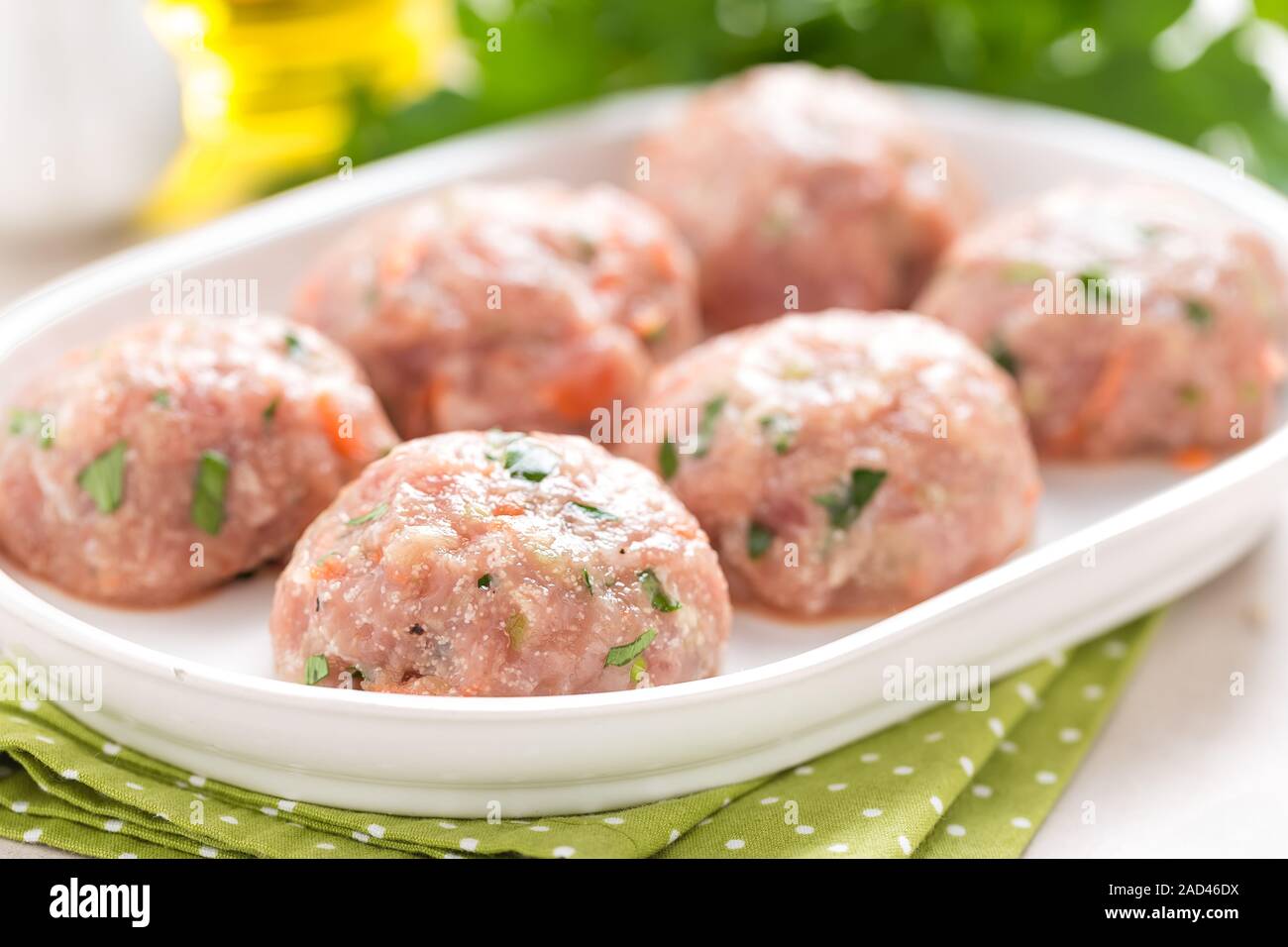 Raw meatballs on white plate, cooking in kitchen Stock Photo - Alamy