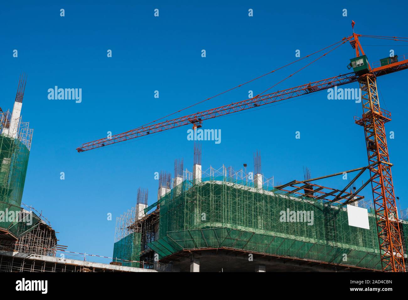 Crane and building construction site against blue sky. Metal ...