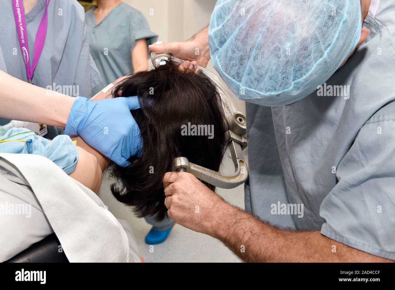 Brain surgery. Female patient having her head immobilised prior to ...